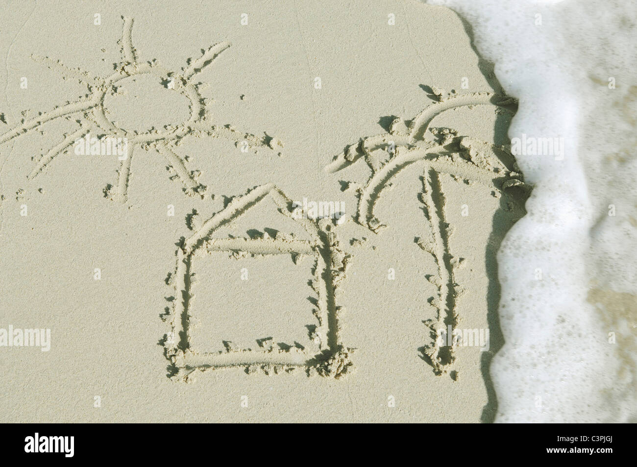 Tree and sun drawn in sand on beach by sea hi-res stock photography and ...