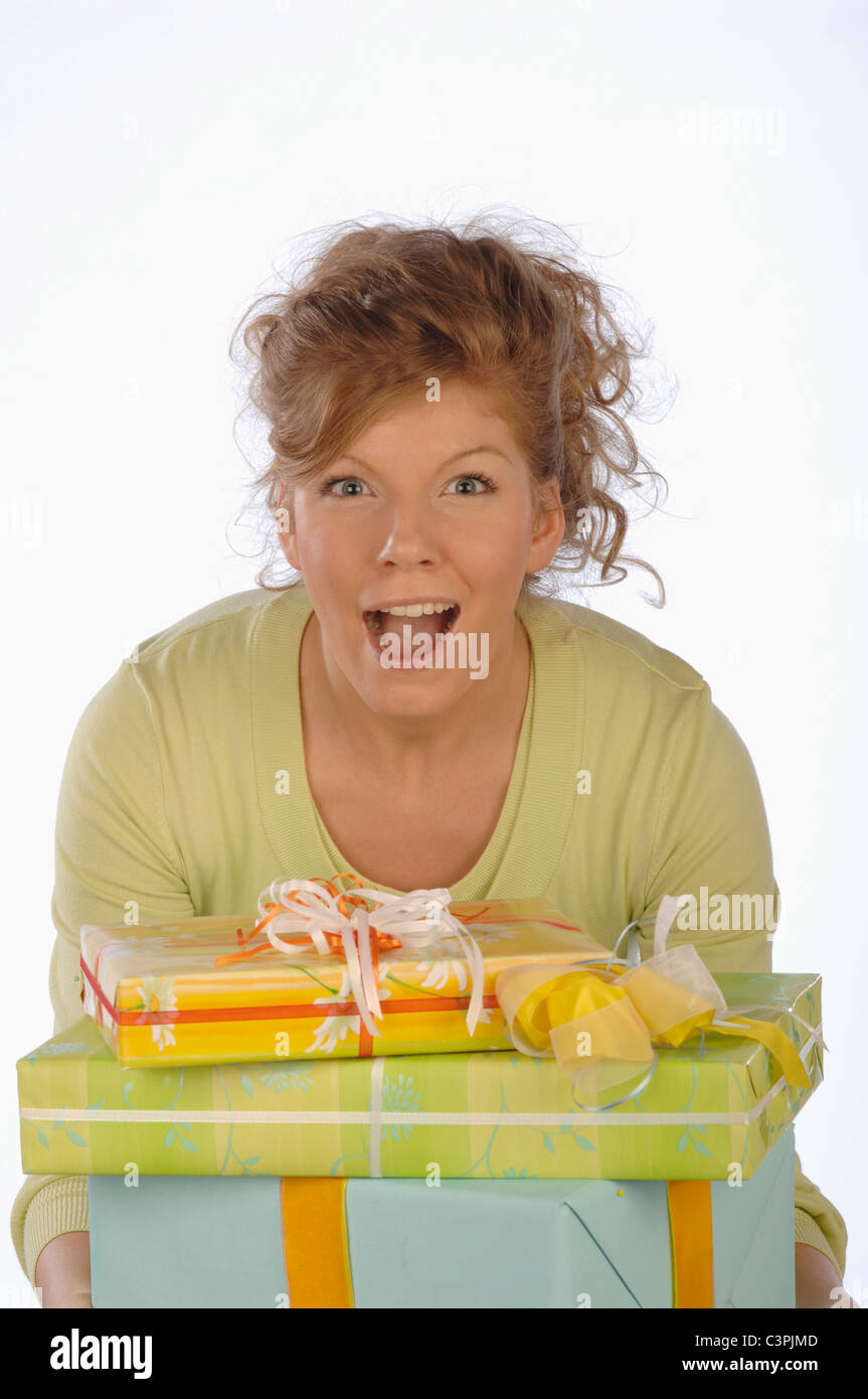 Young woman mouth open with gift packages, portrait Stock Photo - Alamy