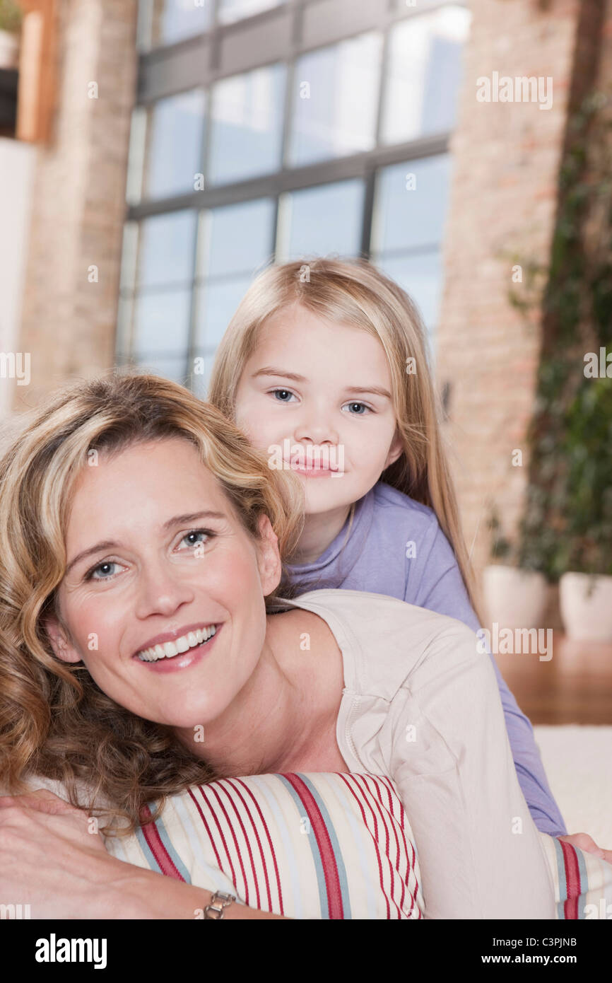 Germany, Cologne, Mother and daughter (4-5) at home, smiling, portrait ...
