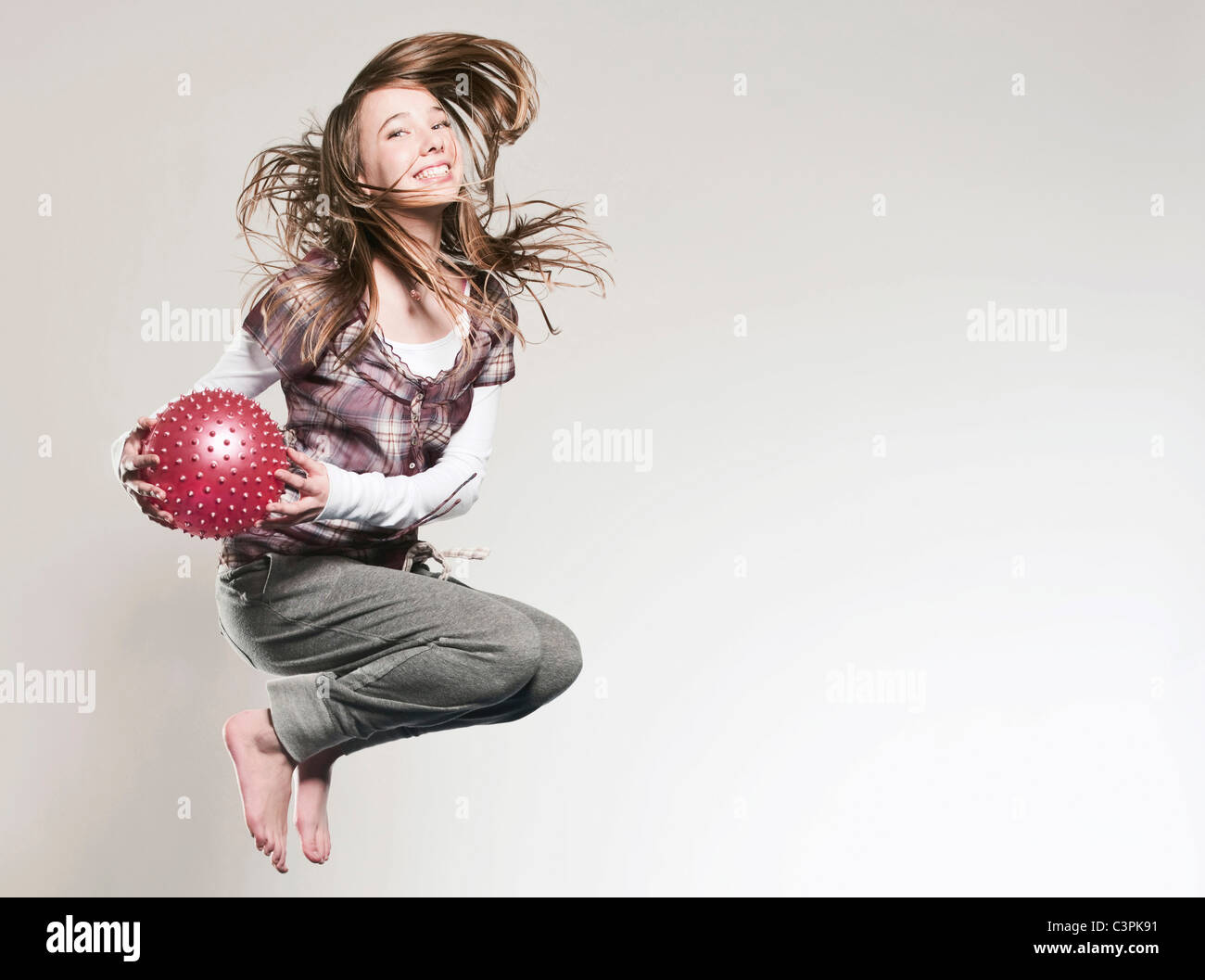 Girl 12 13 holding ball and jumping hi-res stock photography and images ...
