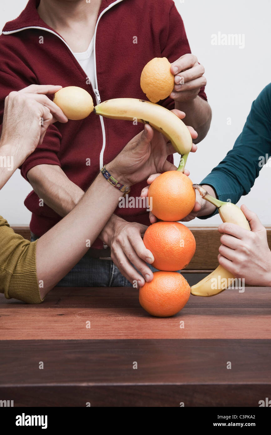 Men and women balancing fruits Stock Photo - Alamy