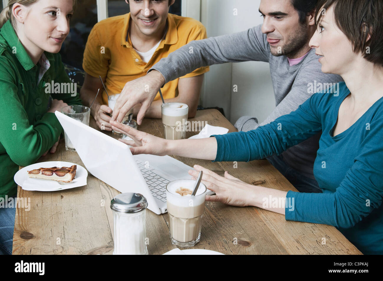 Friends using laptop Stock Photo - Alamy