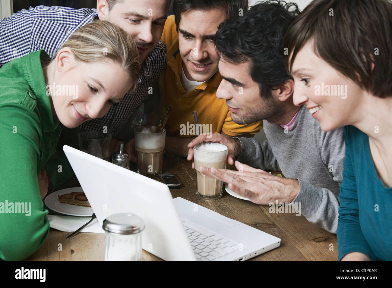 Friends using laptop Stock Photo - Alamy