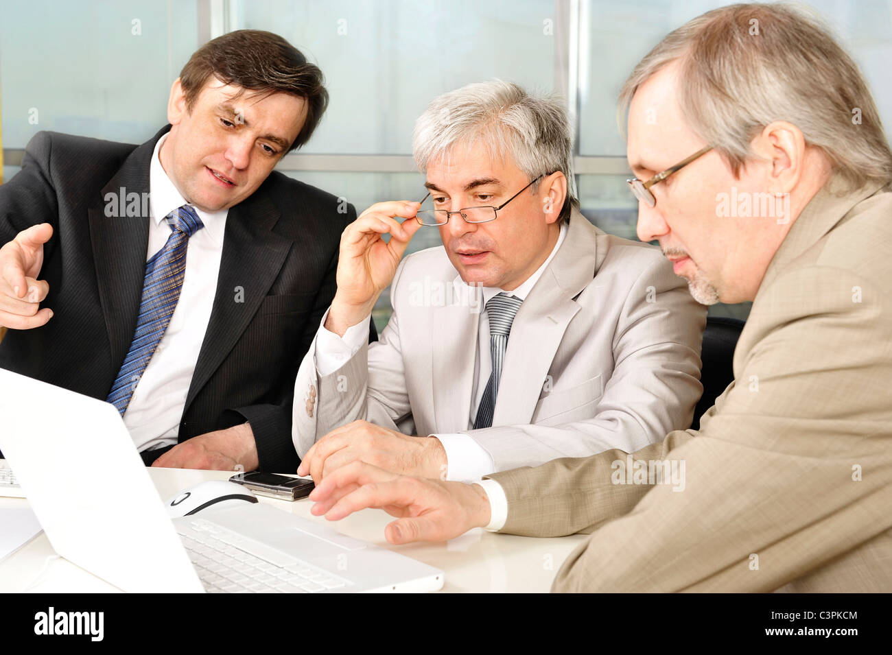 Portrait of three businessmen at the computer. Office background Stock ...
