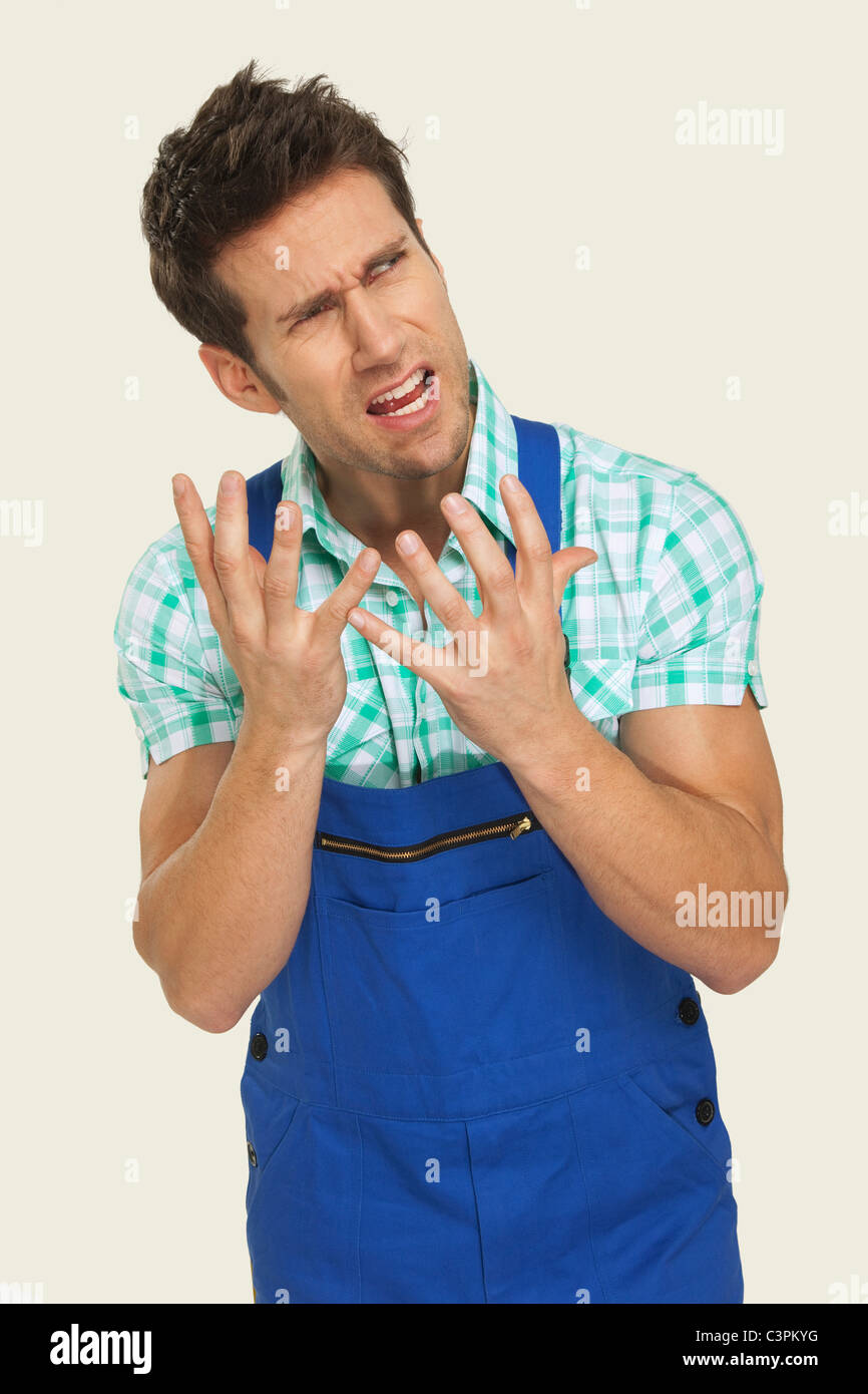 Man in overall showing frustrated expression Stock Photo - Alamy