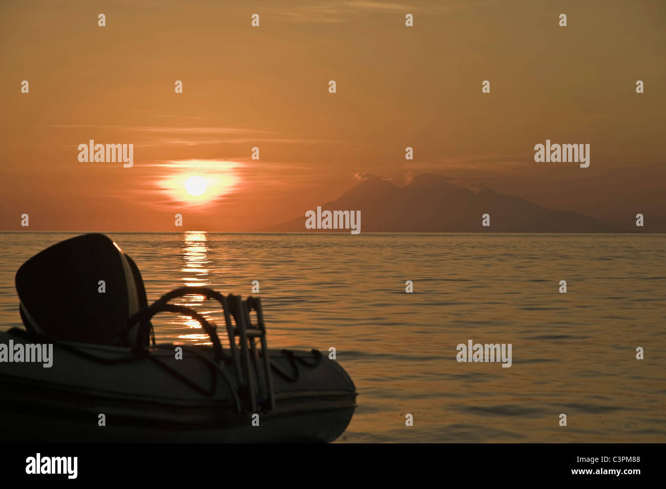 Rubber raft in sea at sunset Stock Photo - Alamy