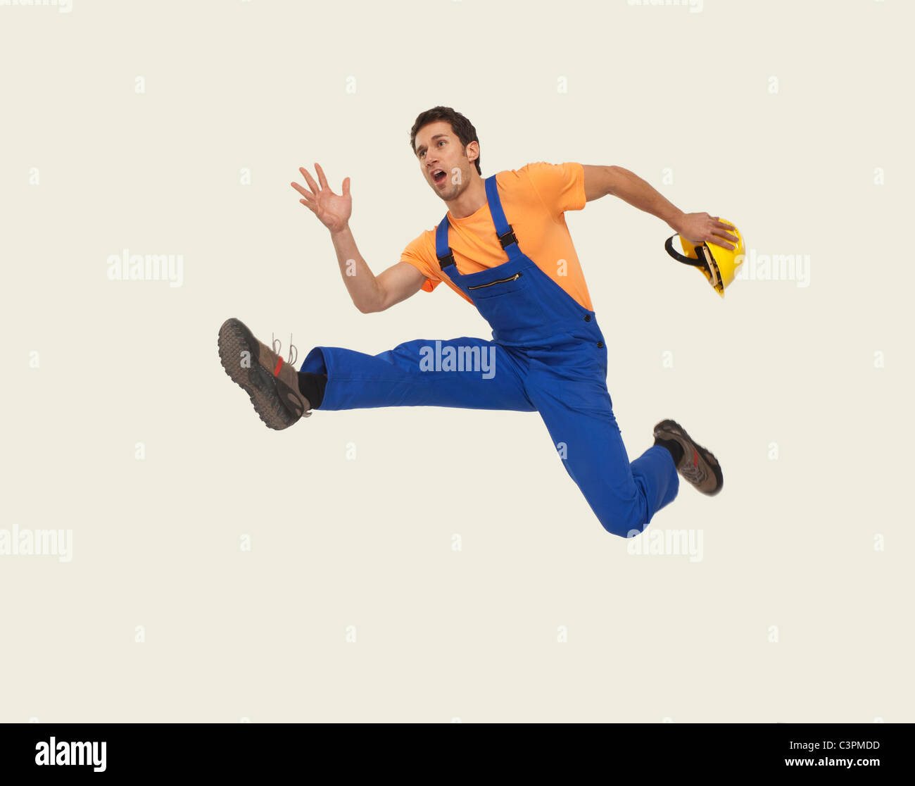 Construction worker holding hard hat, running Stock Photo - Alamy