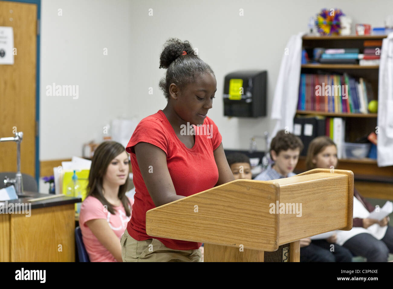 African-American female middle school student speaks at podium in ...
