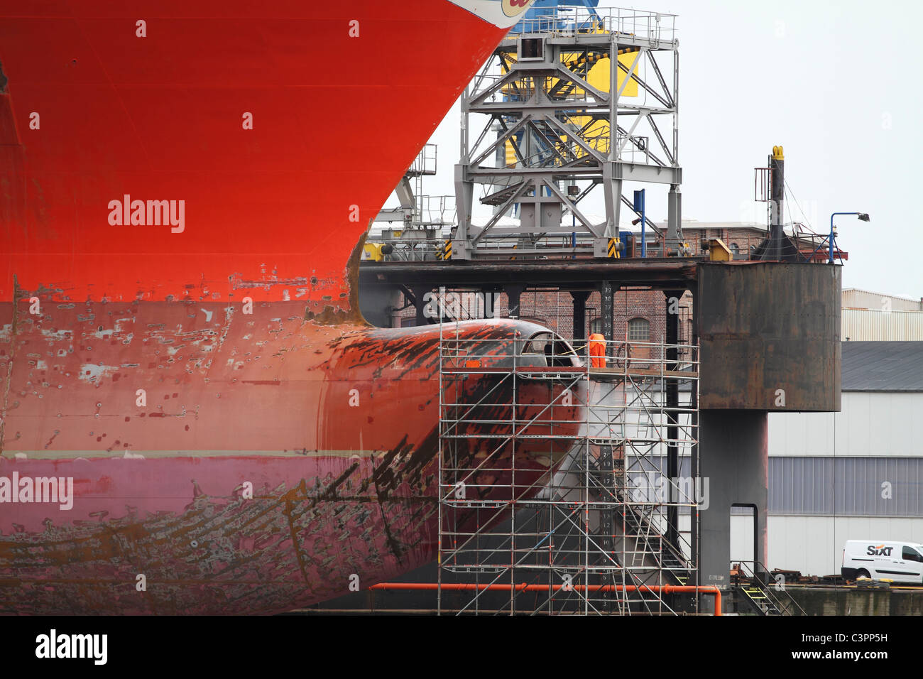 Dock worker working hard to repair / refurbish container ship Stock ...