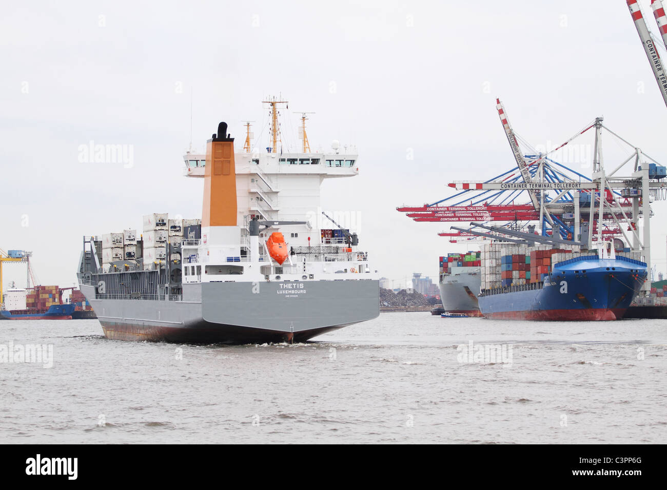 Shot of a medium sized container ship on the river Elbe with bigger ...