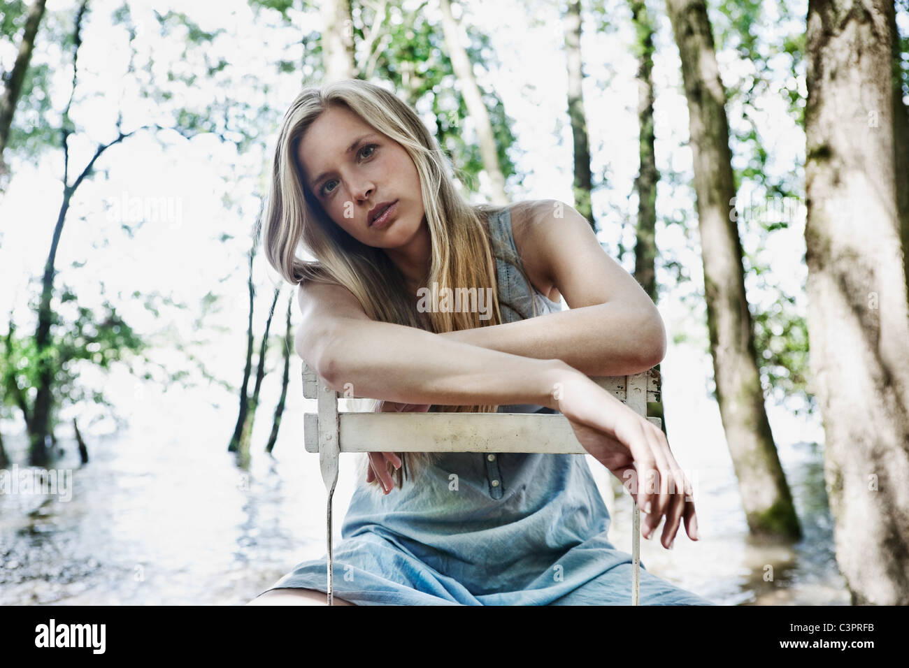 Germany, Cologne, Woman sitting on chair Stock Photo - Alamy