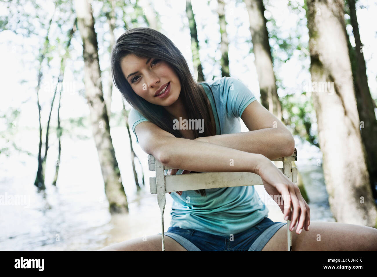 Germany, Cologne, Woman sitting on chair, portrait Stock Photo - Alamy