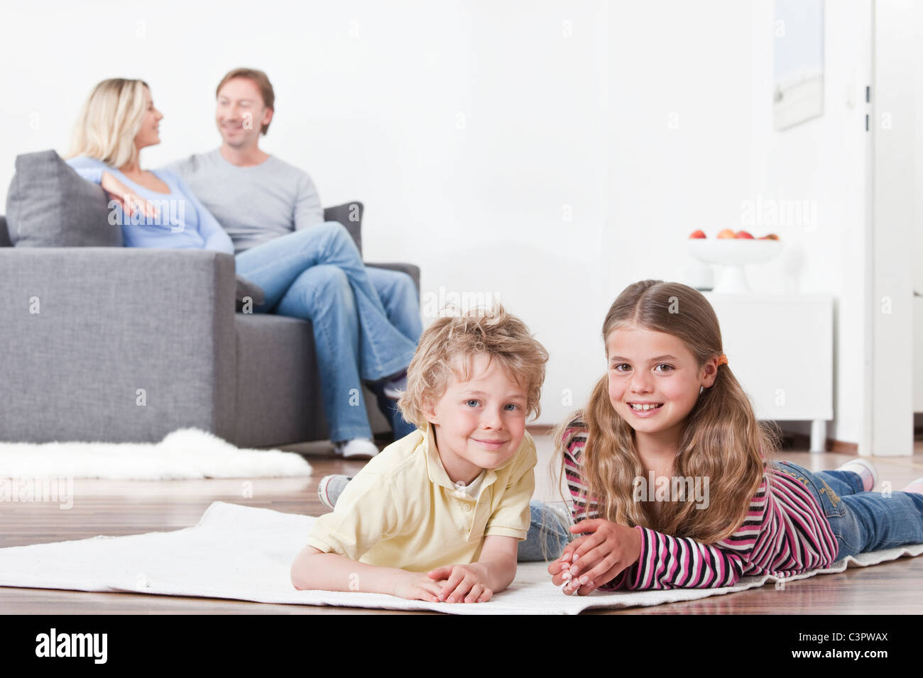 Children smiling with parents in background Stock Photo - Alamy