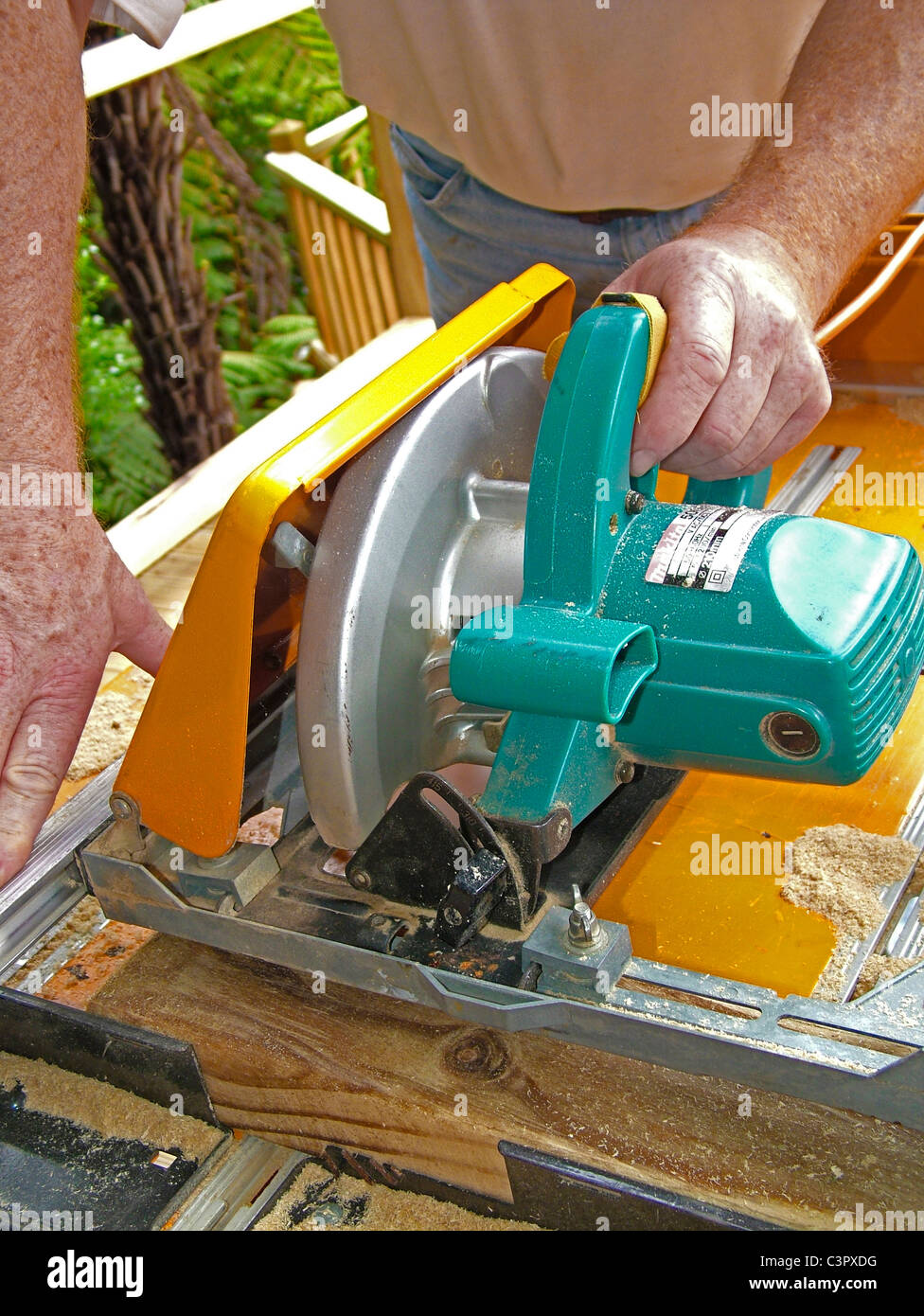 Builder working at saw bench, measuring and cutting Stock Photo - Alamy