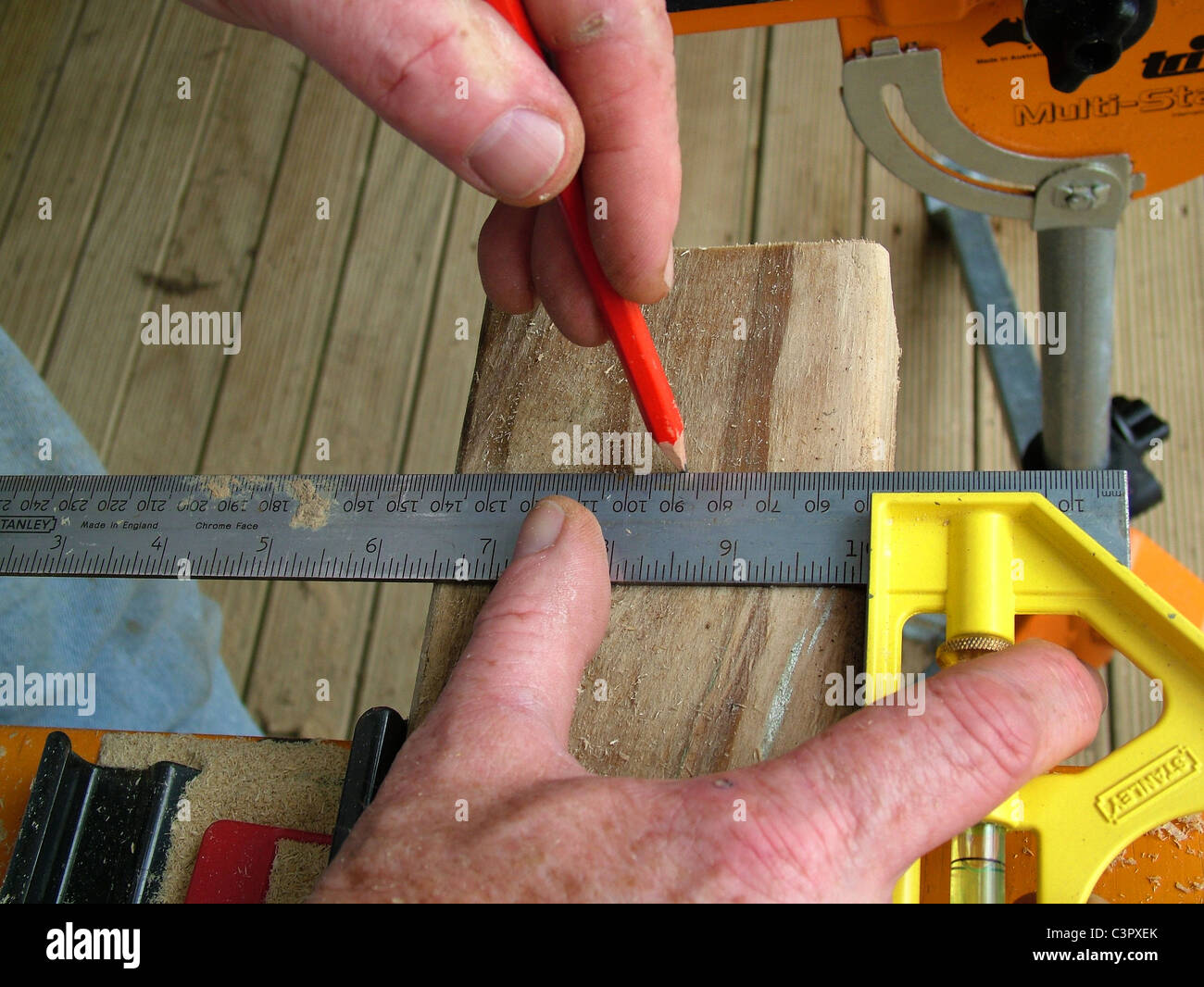 Builder working at saw bench, measuring and cutting Stock Photo - Alamy