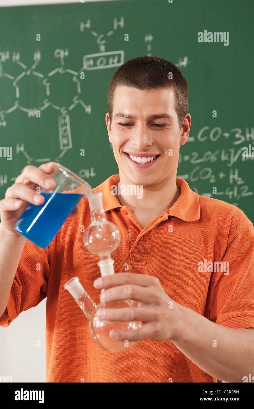 Germany, Emmering, Young man doing experiment, smiling Stock Photo - Alamy