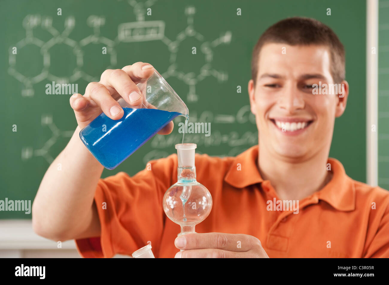 Germany, Emmering, Young man doing experiment, smiling Stock Photo - Alamy