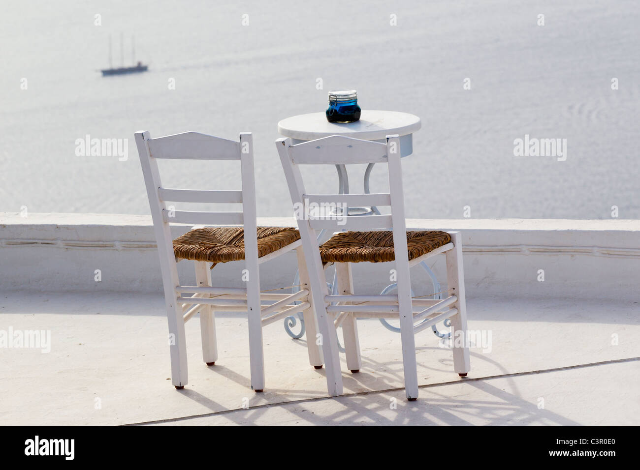 Greece, Cyclades, Thira, Santorini, Firostefani, Table and chairs with ...
