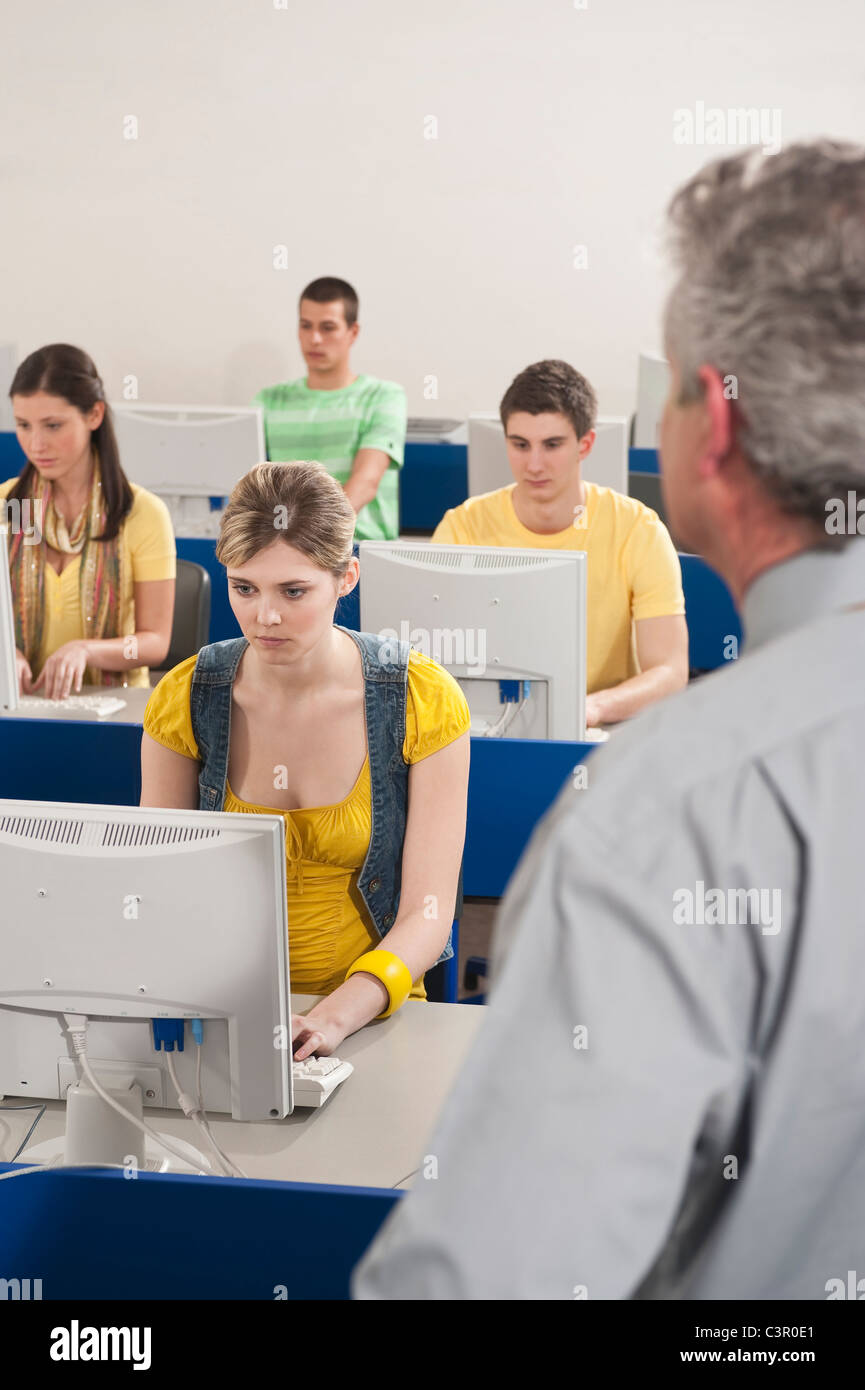 Germany, Emmering, Lecturer watching, students using computer in ...