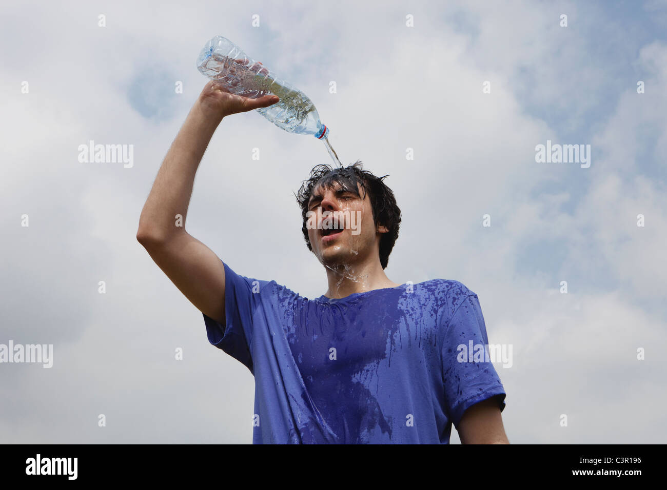 Germany, Cologne, Young man pouring water on himself Stock Photo - Alamy