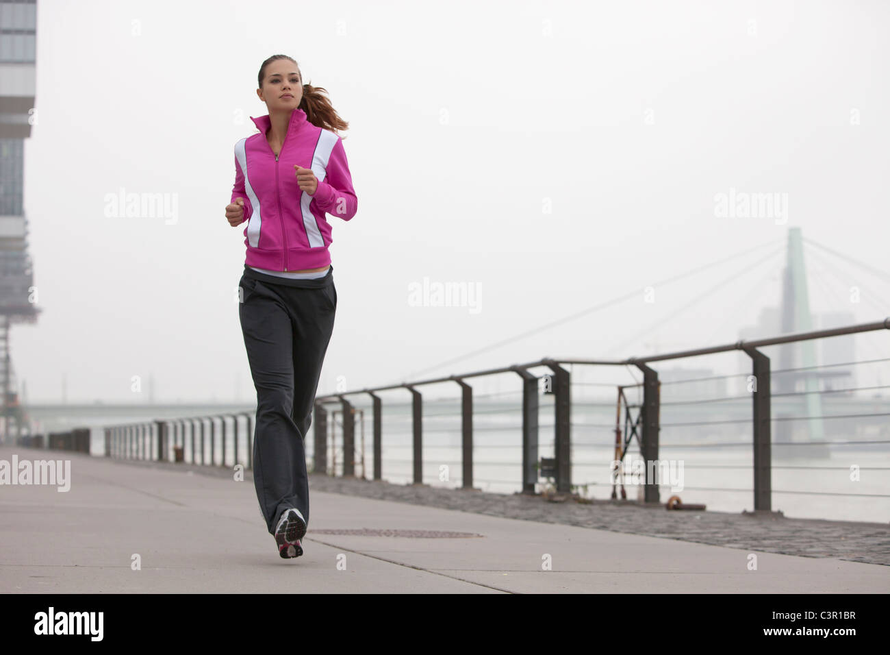 Germany, Cologne, Young woman jogging Stock Photo - Alamy