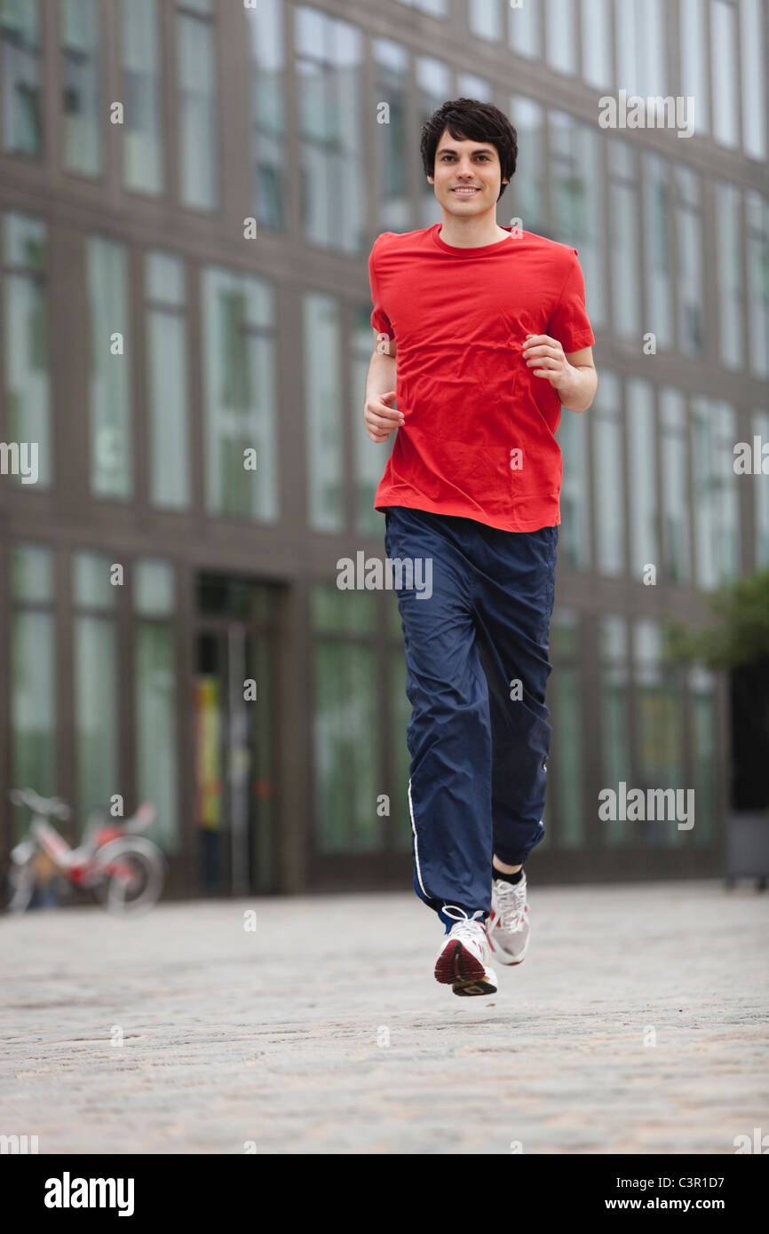 Germany, Cologne, Young man jogging, smiling Stock Photo - Alamy