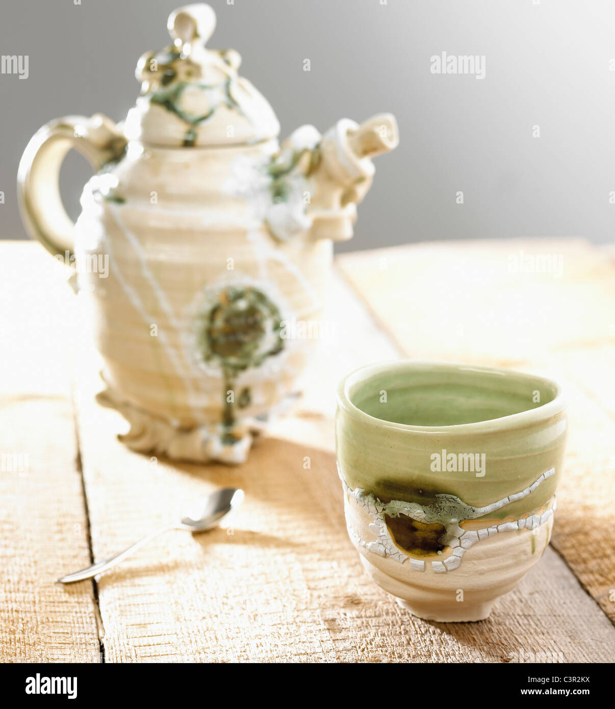 Pottery teapot with tea cup and spoon Stock Photo - Alamy