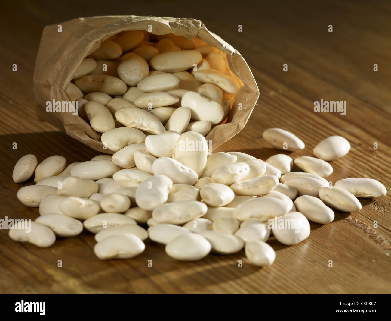 Large white beans spilled on wooden surface Stock Photo - Alamy