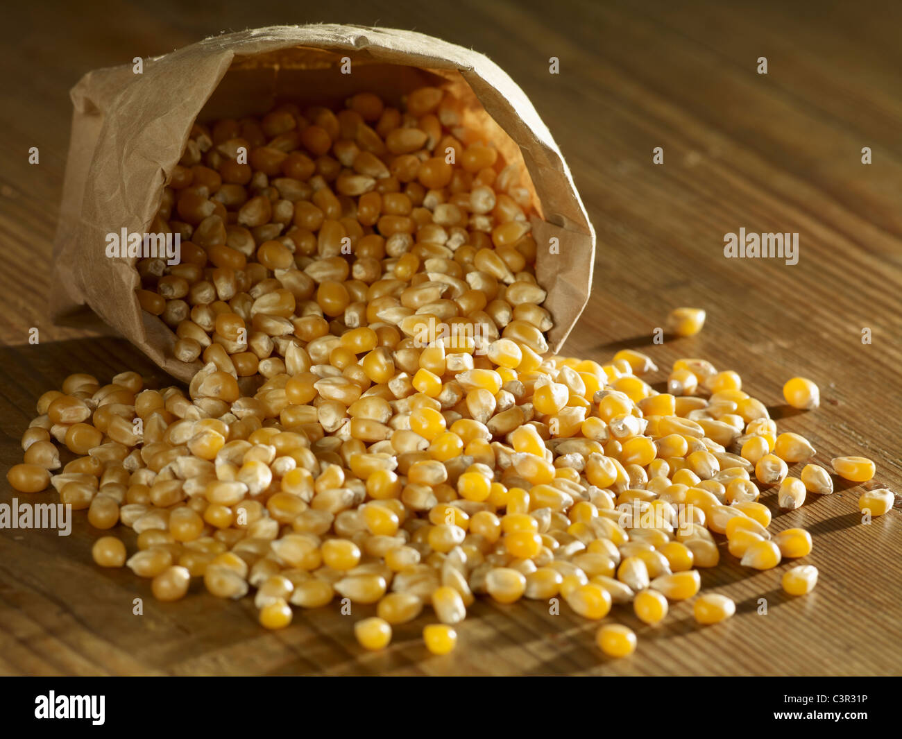 Corn grain spilling on wooden surface Stock Photo - Alamy