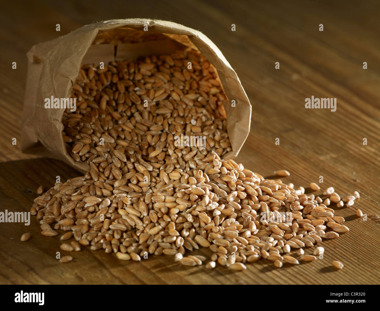 Spelt grain spilling on wooden surface Stock Photo - Alamy