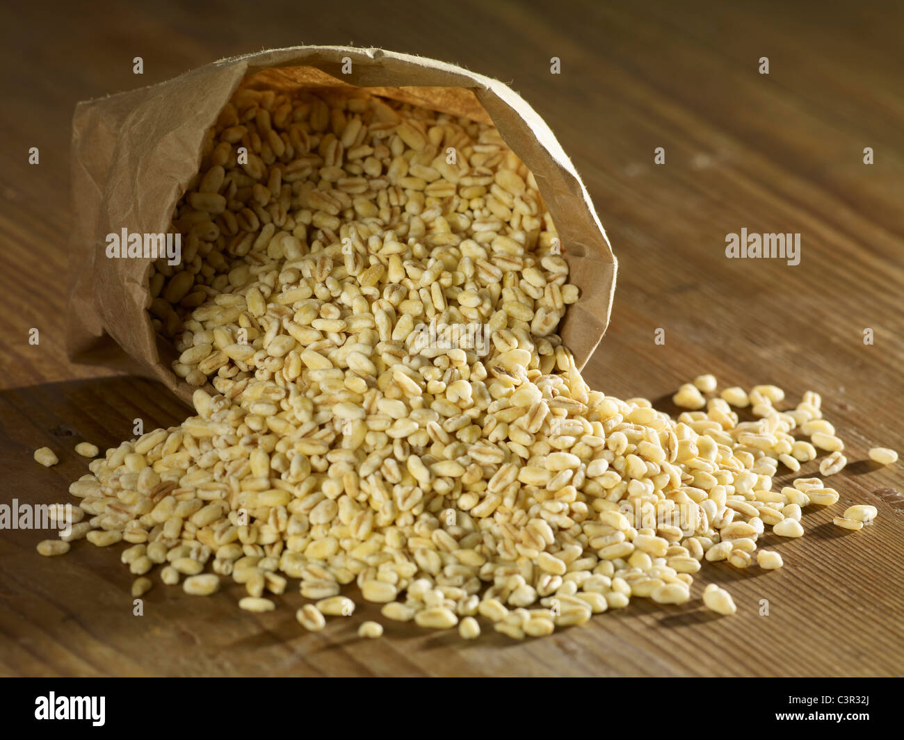 Precooked wheat spilling on wooden surface Stock Photo - Alamy