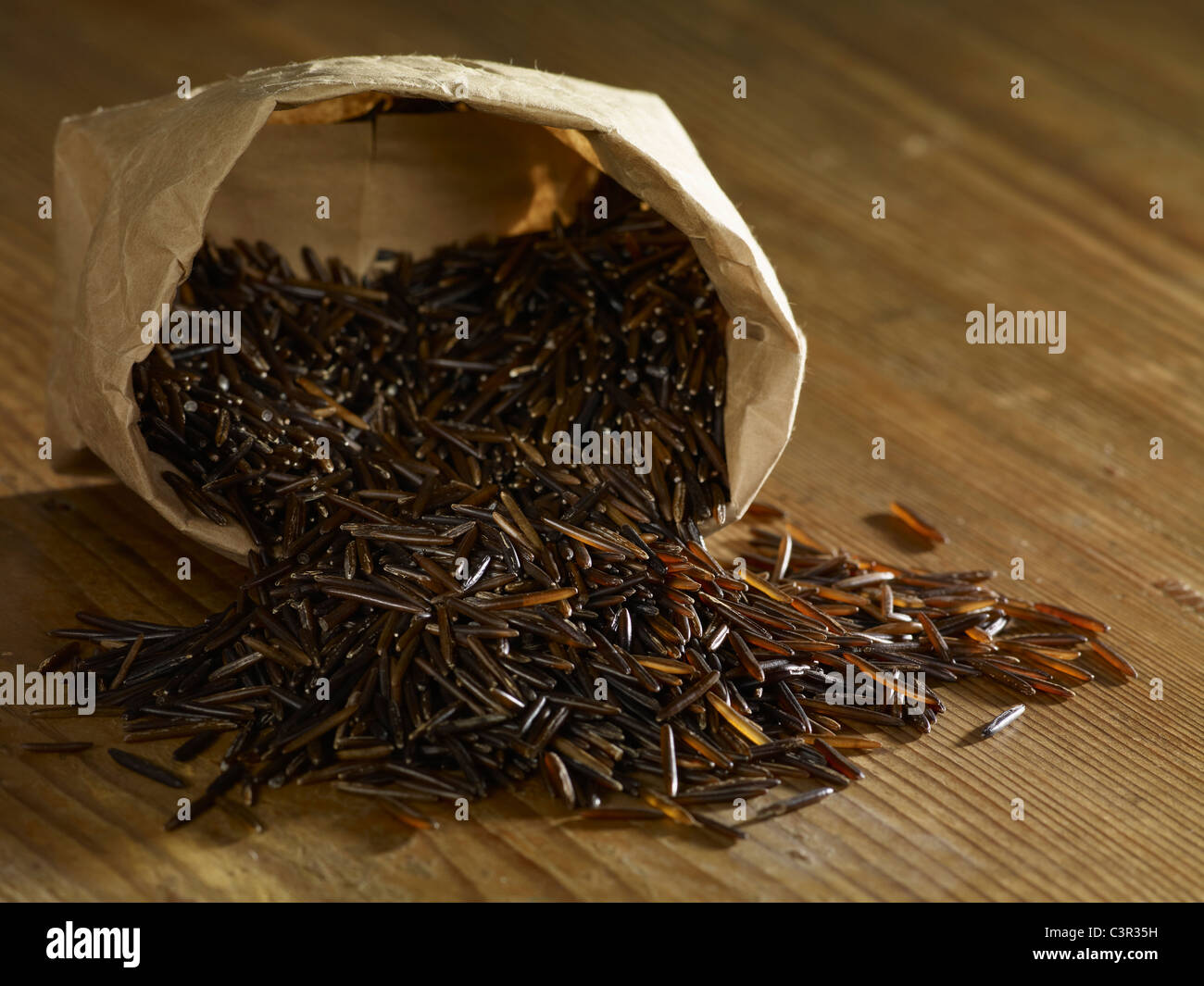 Canadian wild rice spilling on wooden surface Stock Photo - Alamy