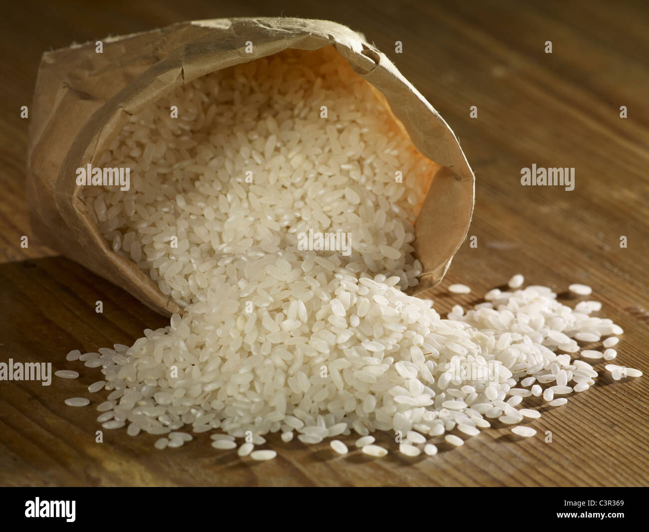 Round corn rice spilling on wooden surface Stock Photo - Alamy