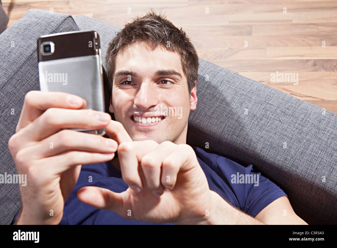 Man text messaging on mobile phone, smiling, close-up Stock Photo - Alamy