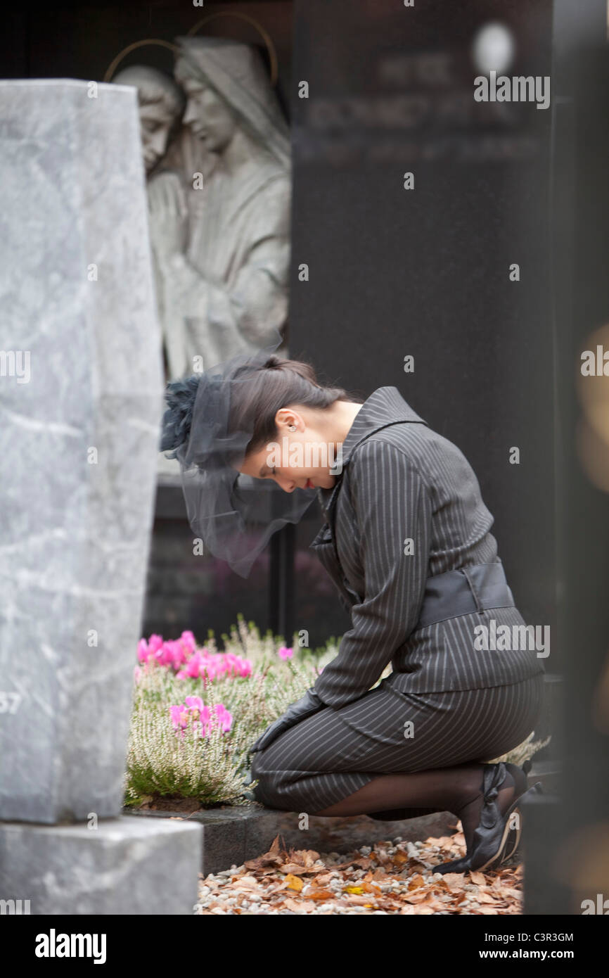 Germany, Bavaria, Young woman visiting a tombstone in cemetery Stock ...
