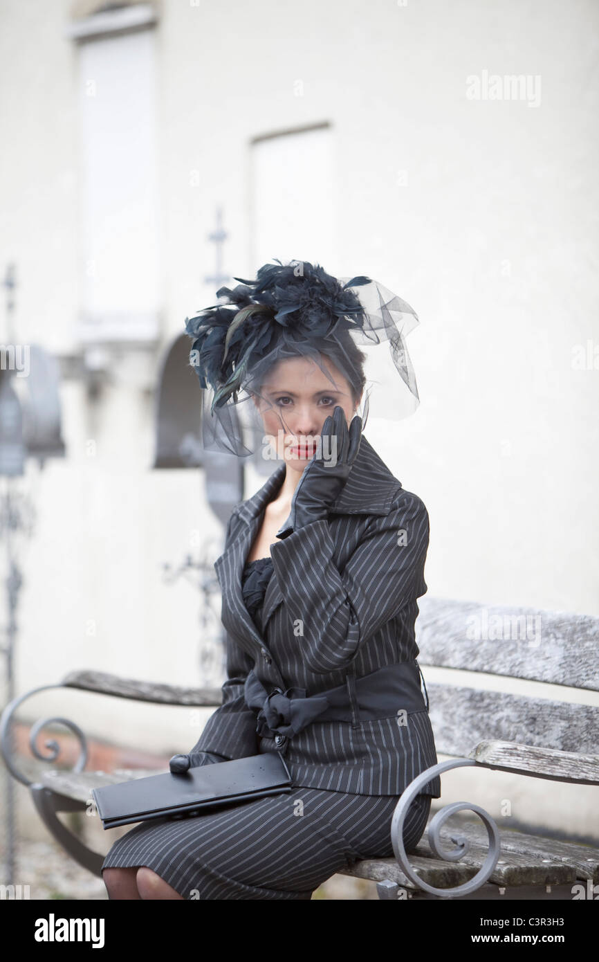 Germany, Bavaria, Young woman sitting on bench and crying Stock Photo ...