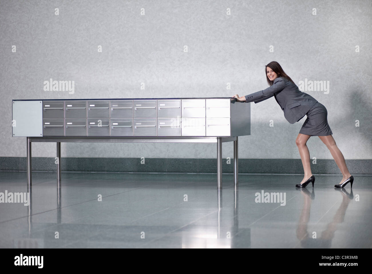 Germany, Bavaria, Business woman pushing table Stock Photo - Alamy