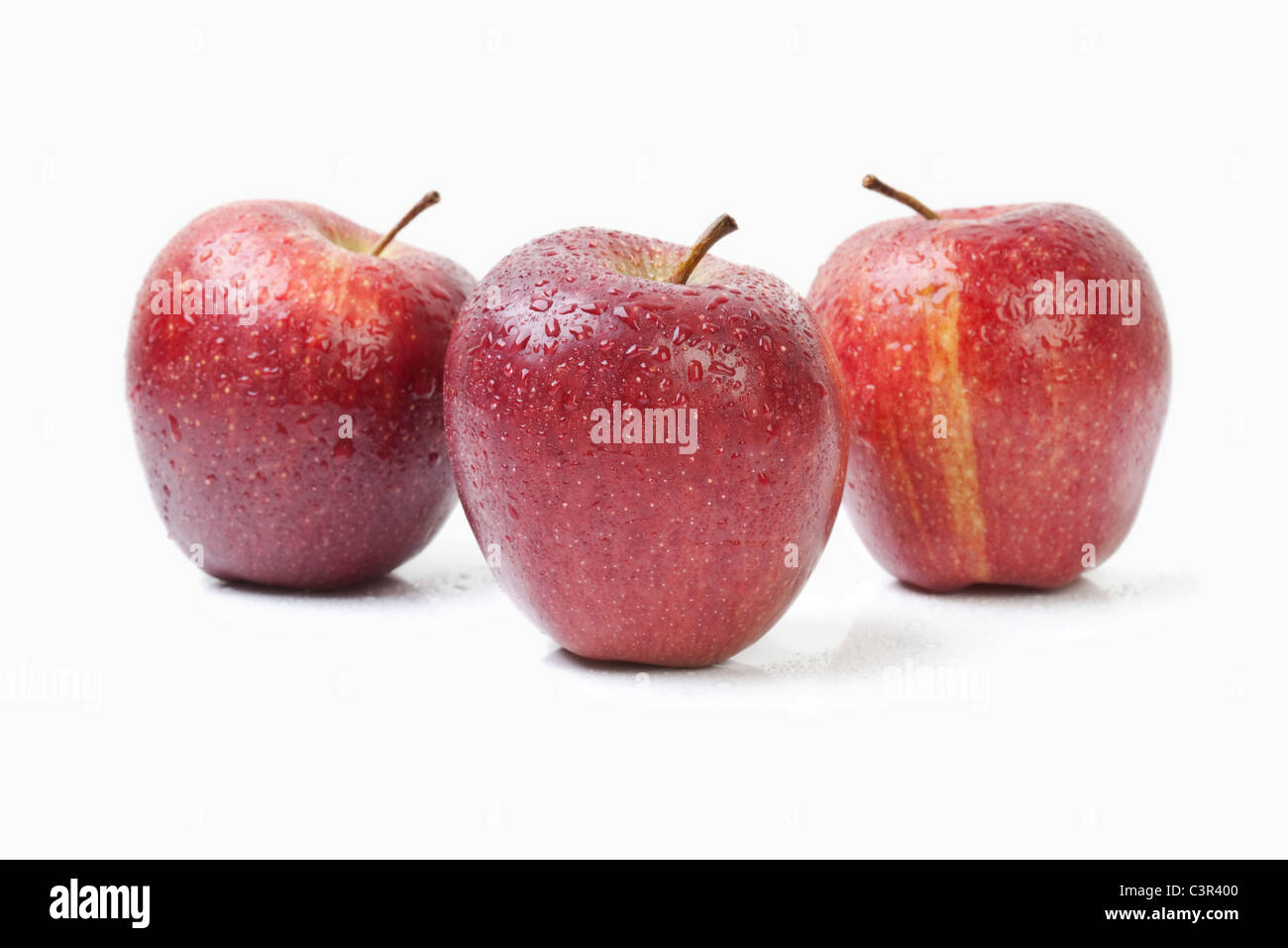 Three red apples on white background Stock Photo - Alamy