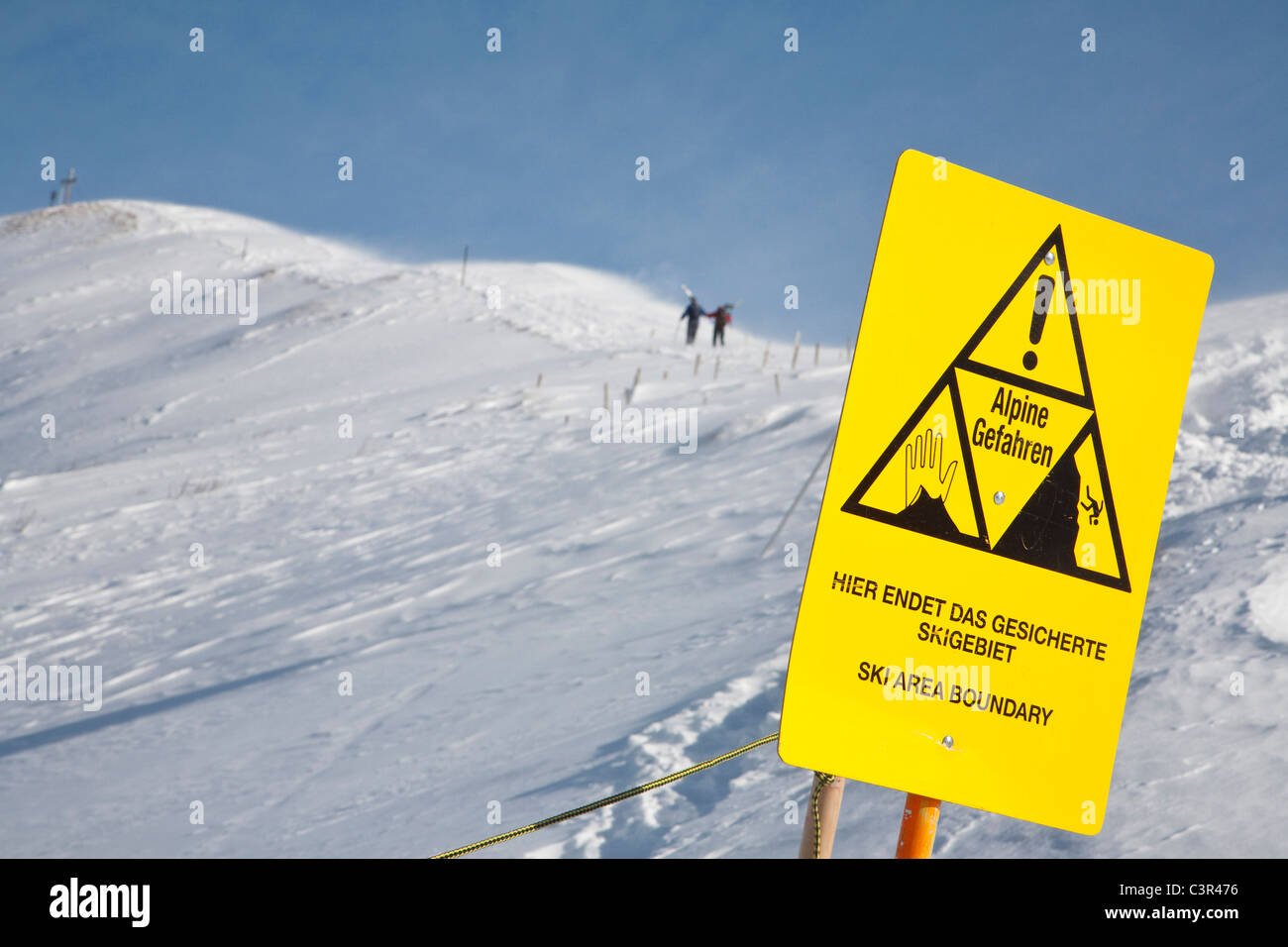 Germany, Bavaria, Warning sign with people skiing in background Stock ...