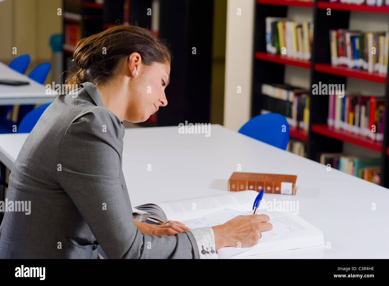 Female student working in the library Stock Photo - Alamy