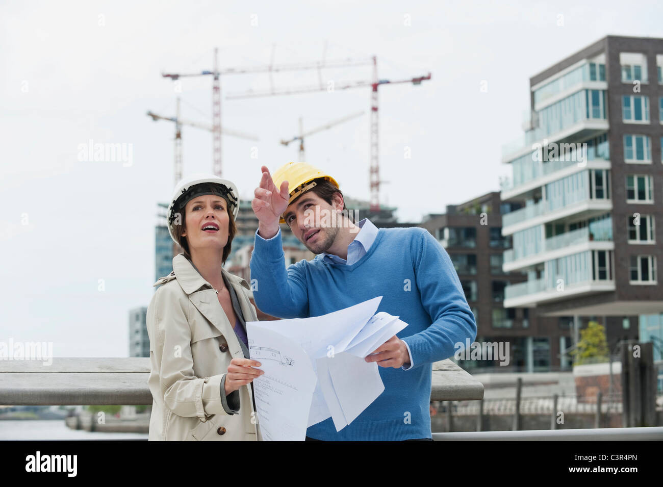 Germany, Hamburg, Man and woman with blueprint at harbour Stock Photo ...