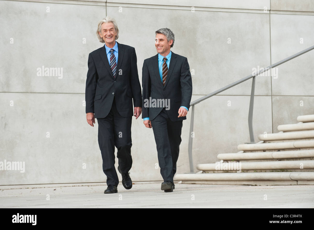 Germany, Hamburg, Businessmen walking together, smiling Stock Photo - Alamy