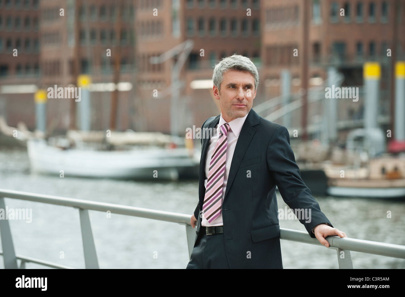 Germany, Hamburg, Businessman looking away at harbour Stock Photo - Alamy