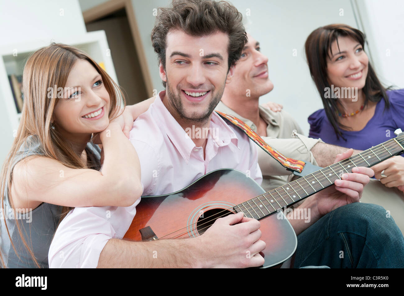 Happy friends playing guitar together Stock Photo - Alamy
