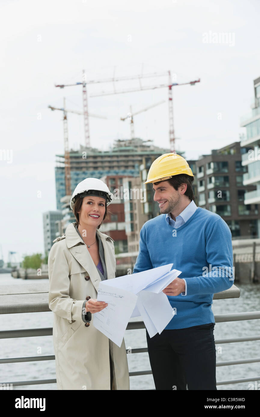 Germany, Hamburg, Man and woman with blueprint at harbour Stock Photo ...