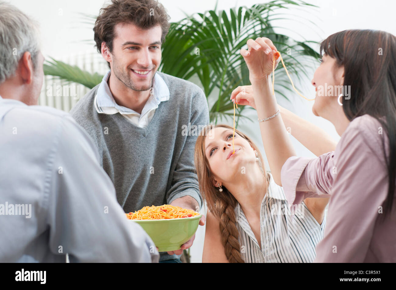 Friends tasting spaghetti for lunch Stock Photo - Alamy