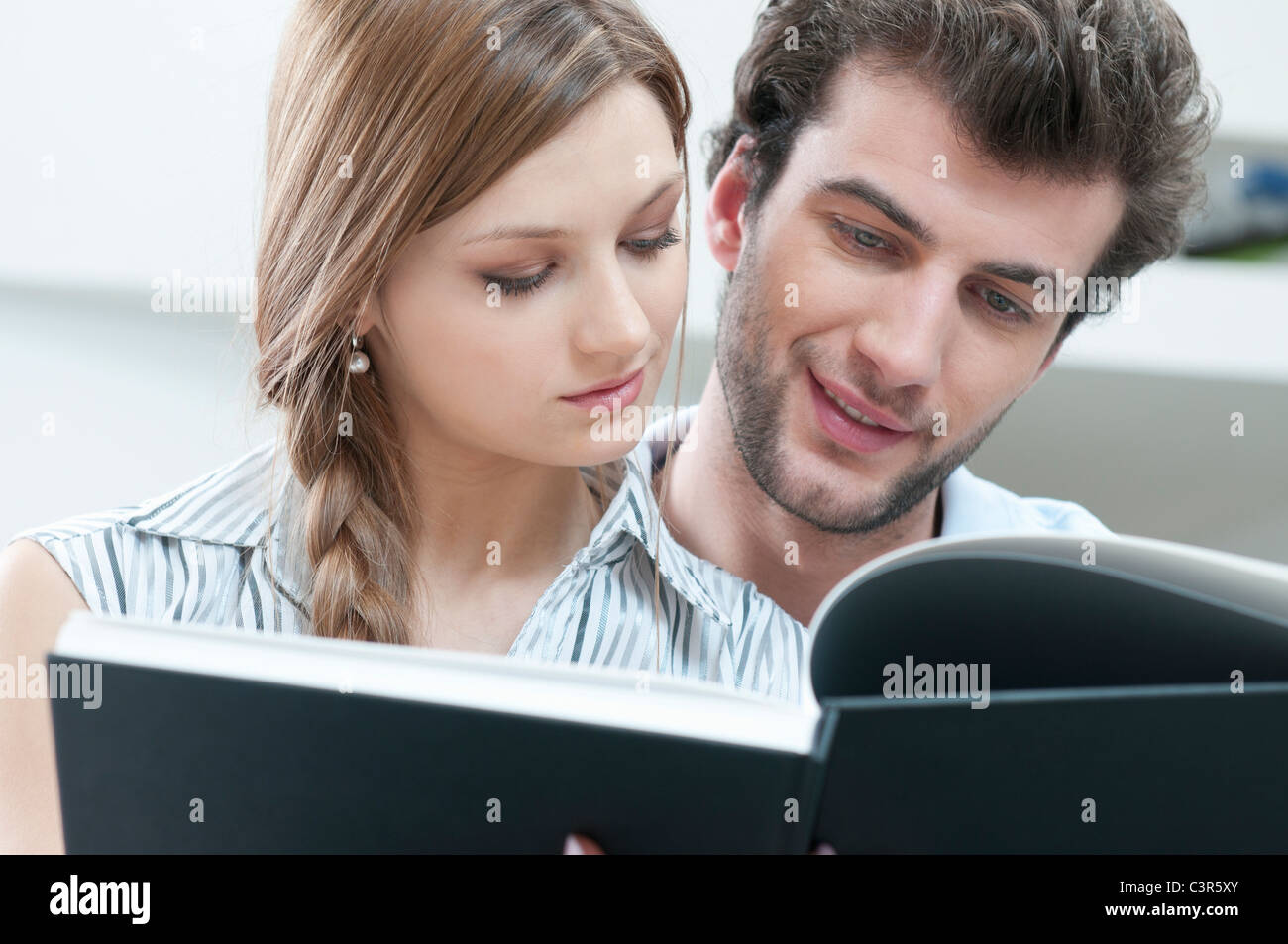 Young couple reading book together Stock Photo - Alamy