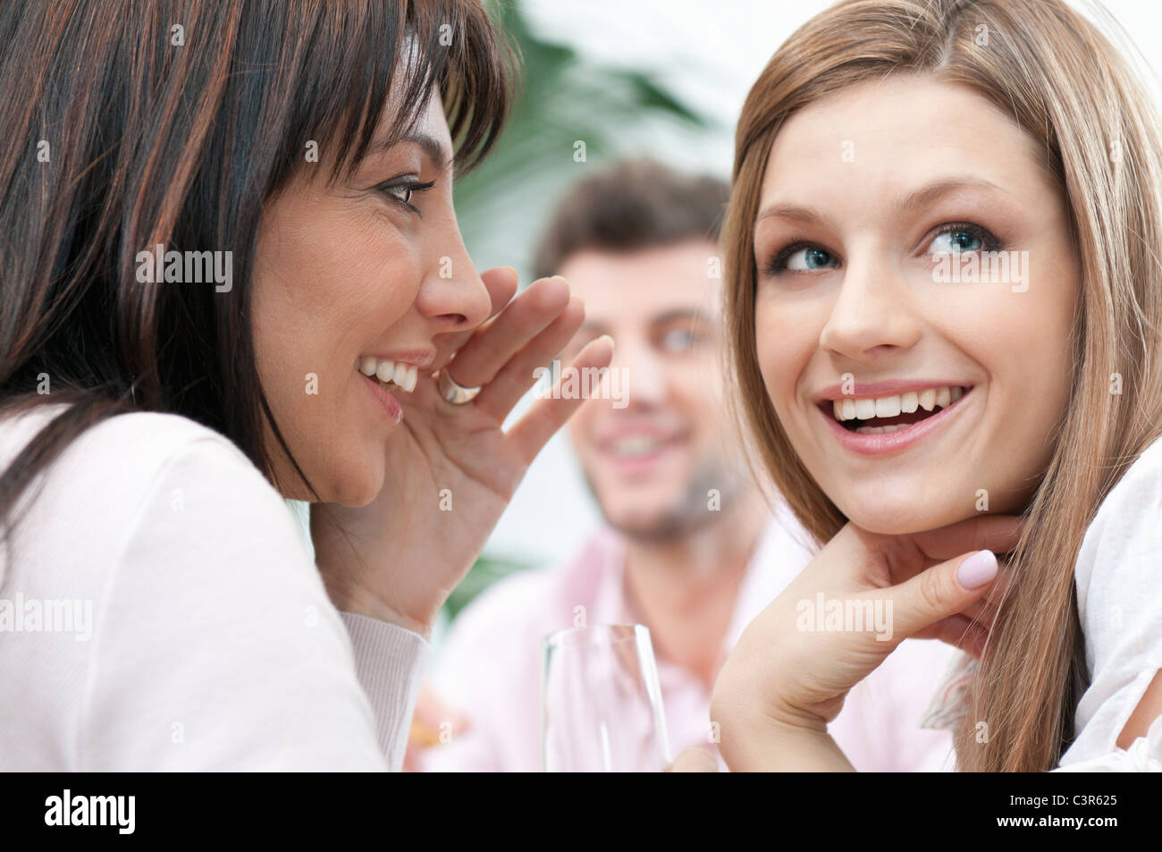 Girls whispering a secret Stock Photo - Alamy