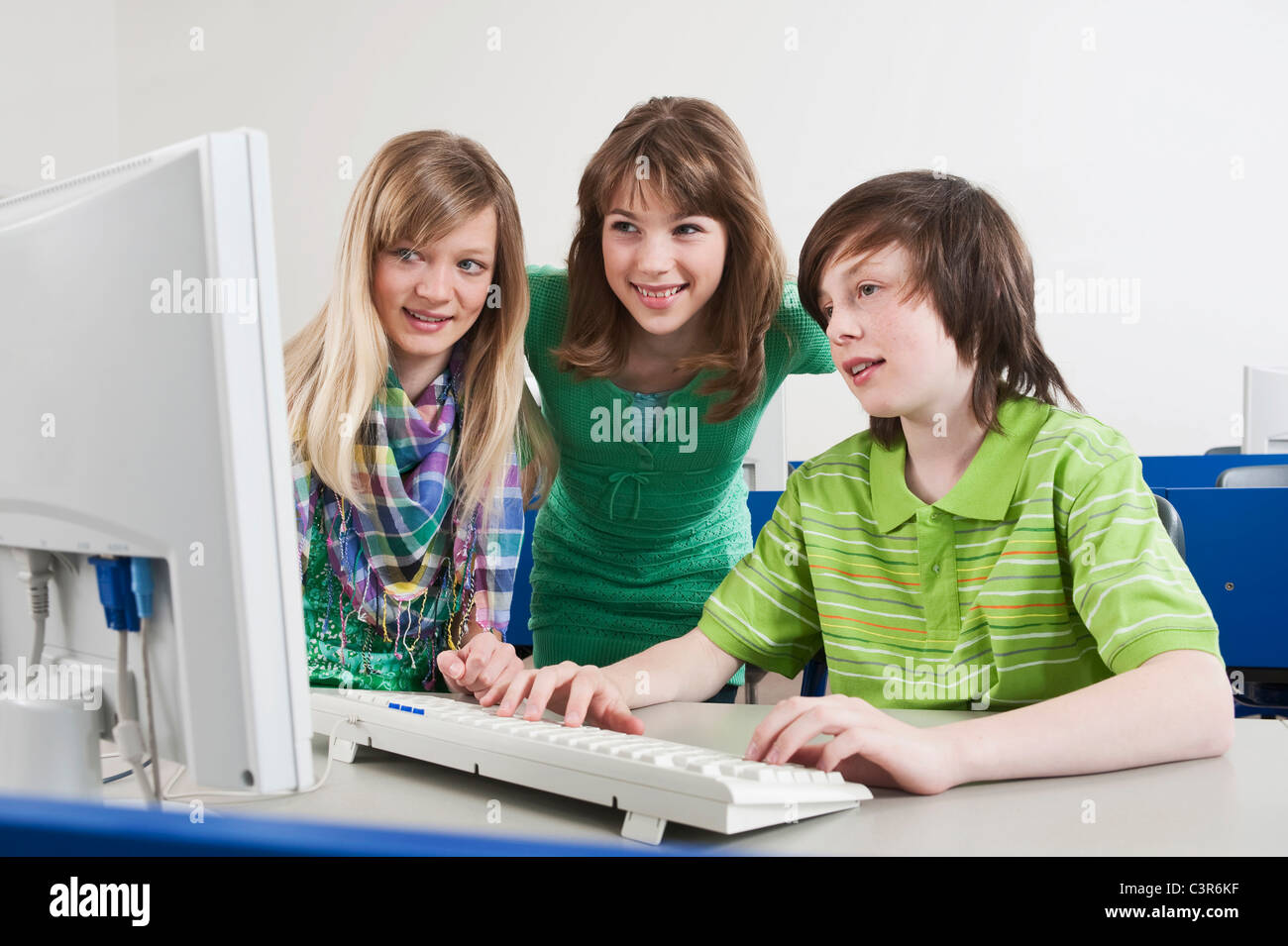 Germany, Emmering, Boy using computer and girls watching, smiling Stock ...