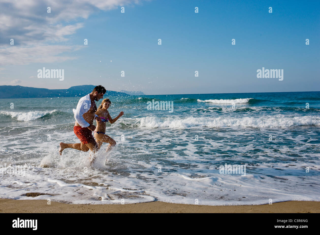 couple running on the beach Stock Photo - Alamy